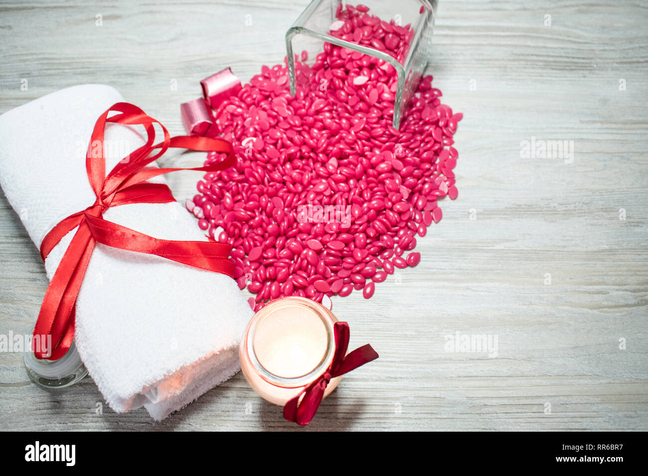 on the table is a red granulated wax, candy, a white towel and a ...