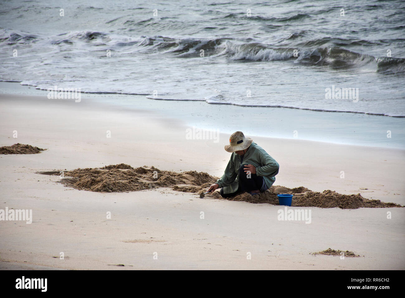 Thai old women people use ladle digging find shell and shellfish on the ...