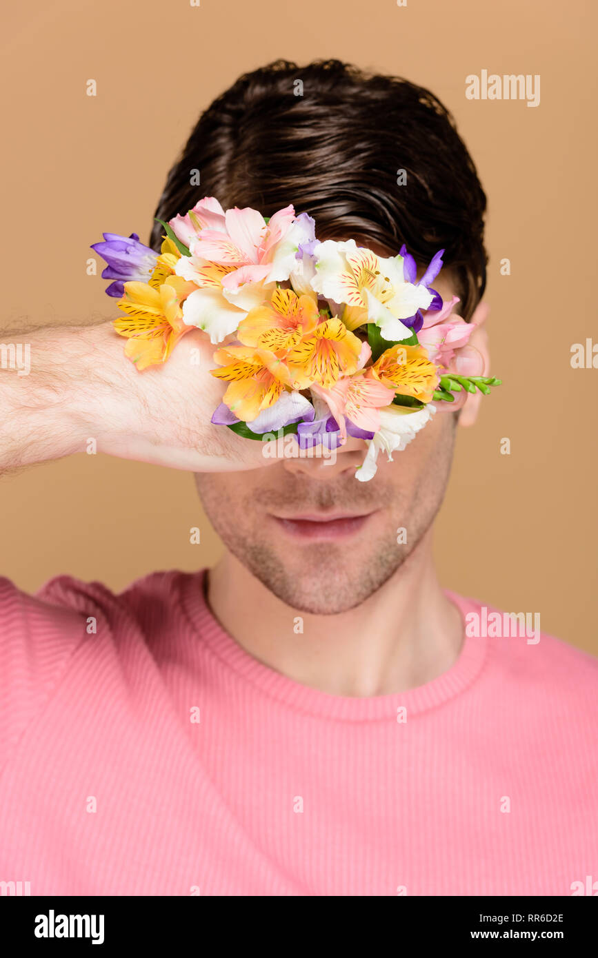 man covering face with flowers on hand isolated on beige Stock Photo ...
