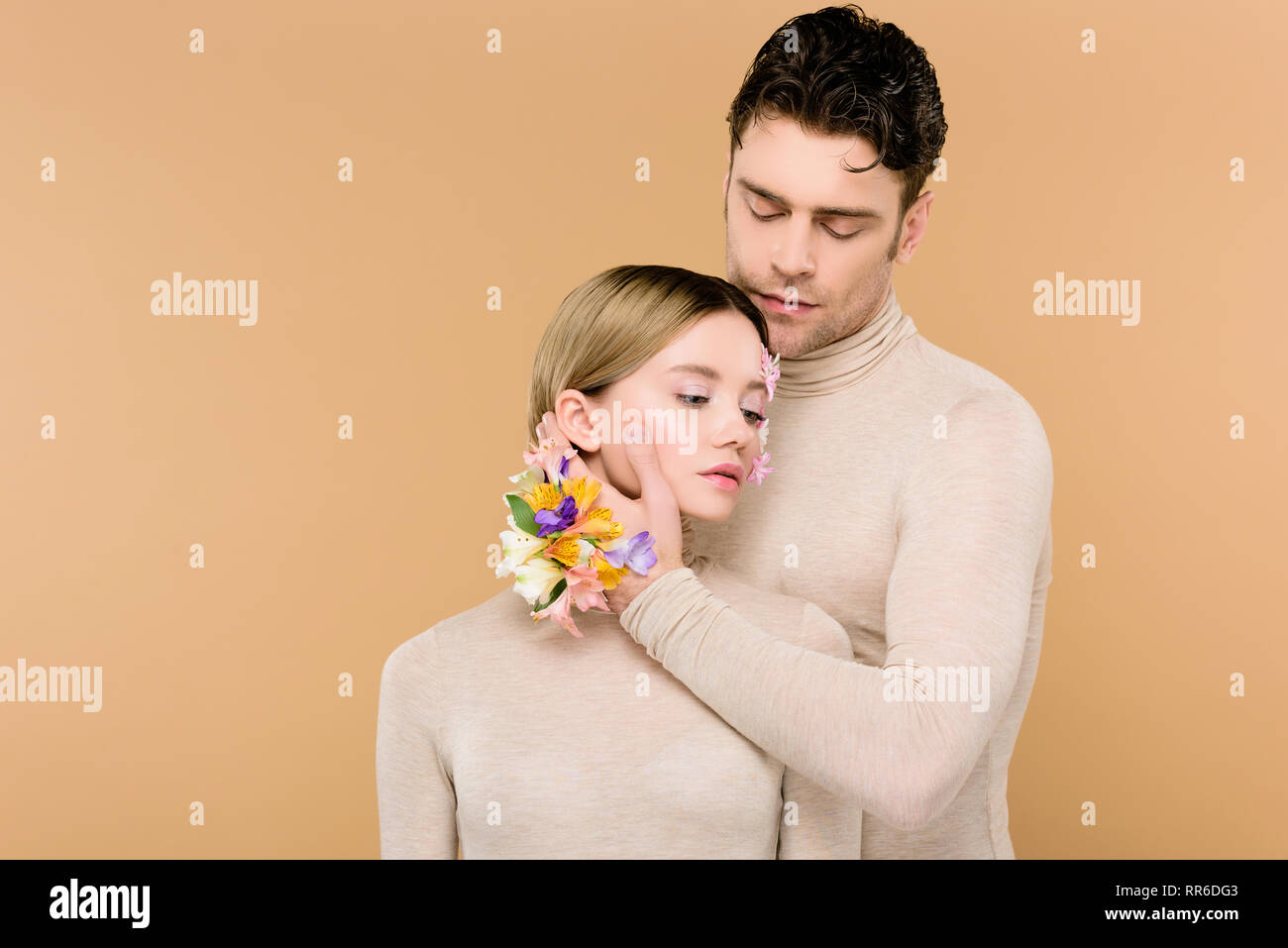 tender man with alstroemeria flowers on hand touching face of pretty ...