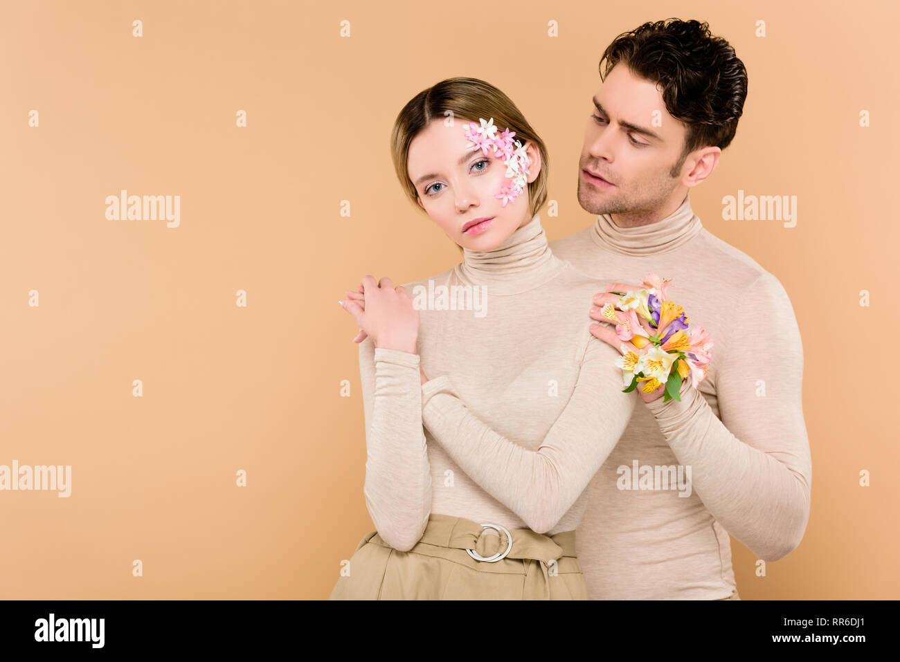 tender man with alstroemeria flowers on hand looking at beautiful ...