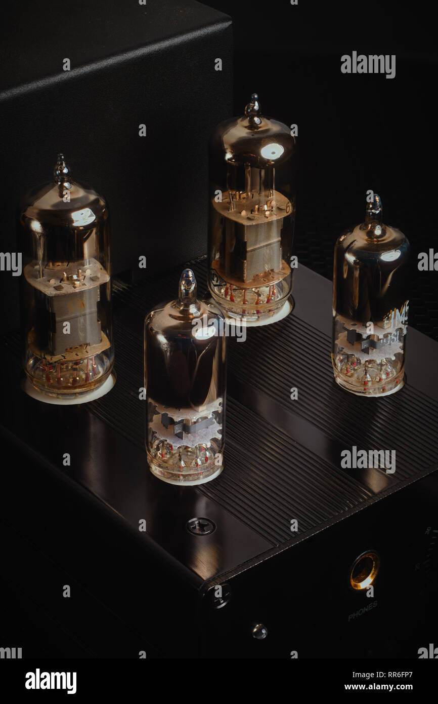 Headphone amplifier with four vacuum tubes / valves against a black ...