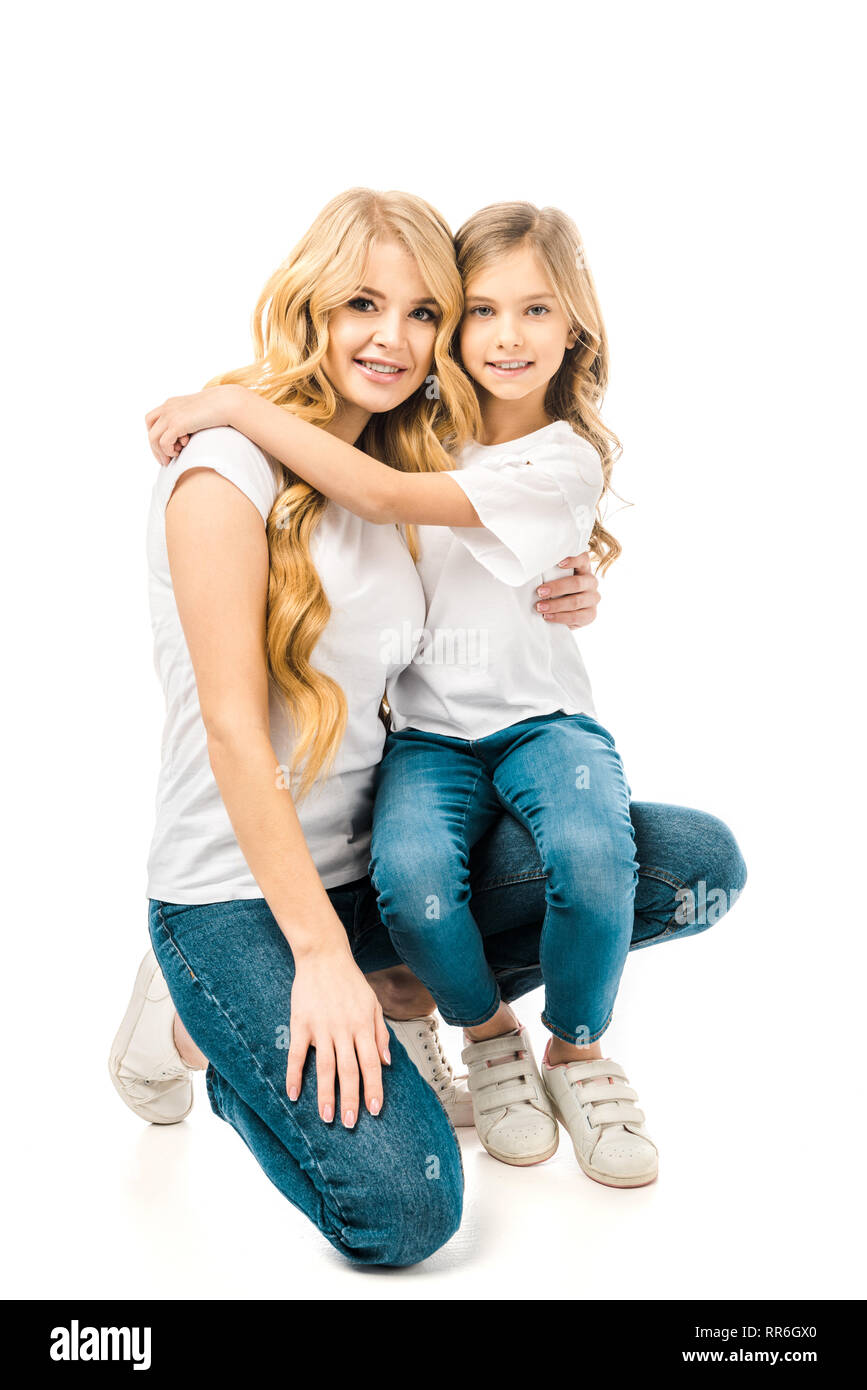 adorable daughter embracing mother while sitting on moms knee isolated ...