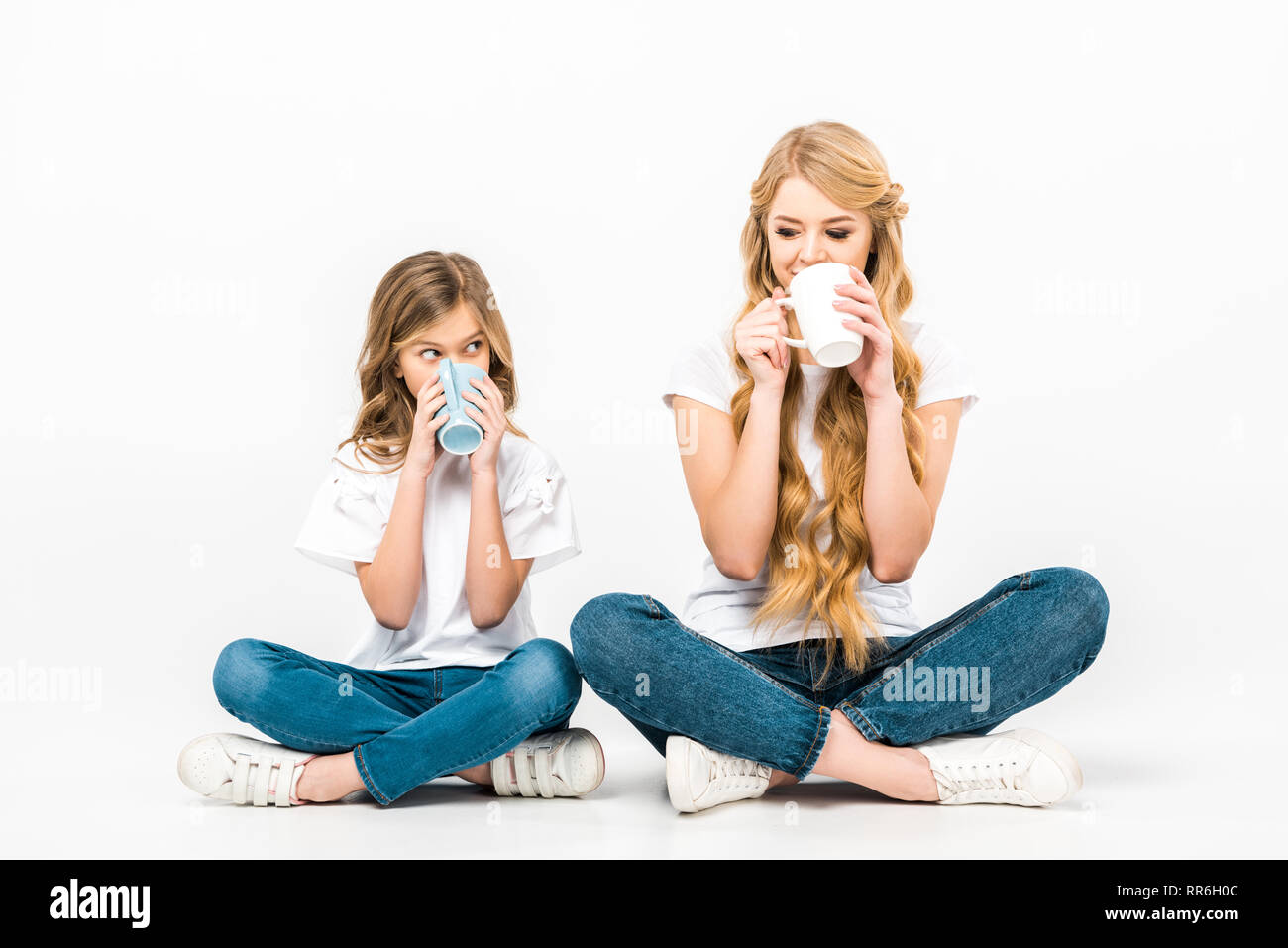 Cheerful Mother And Daughter Drinking Coffee While Sitting On Floor