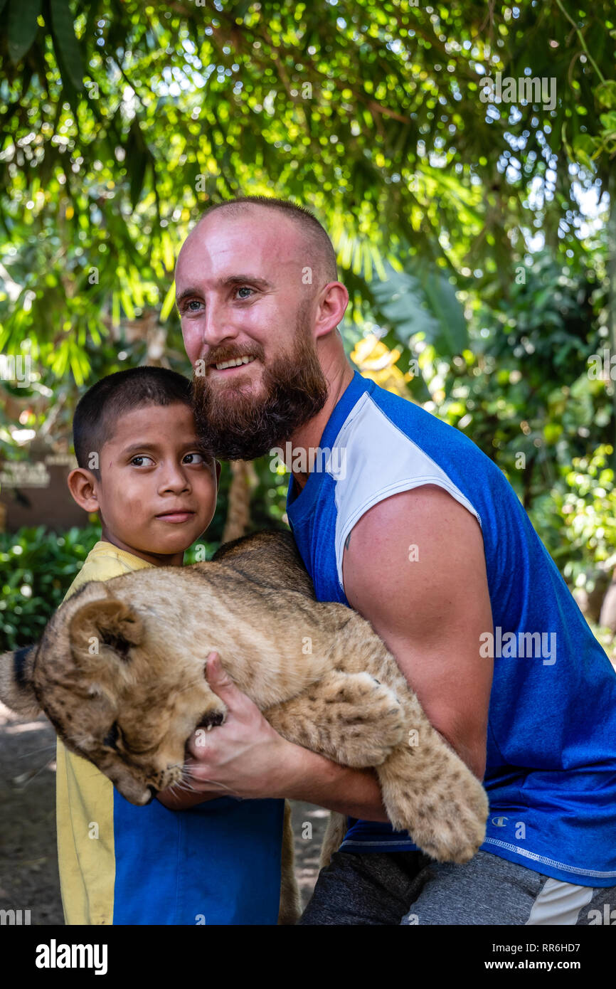 latin child and caucasian man holding baby lion in Guatemalan zoo Stock ...