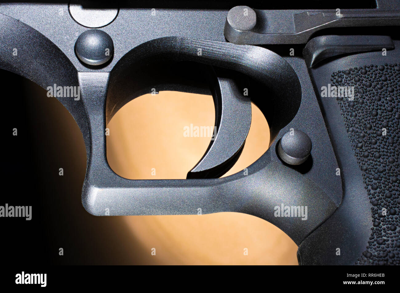 Semi automatic pistol trigger with a brown and black background Stock ...