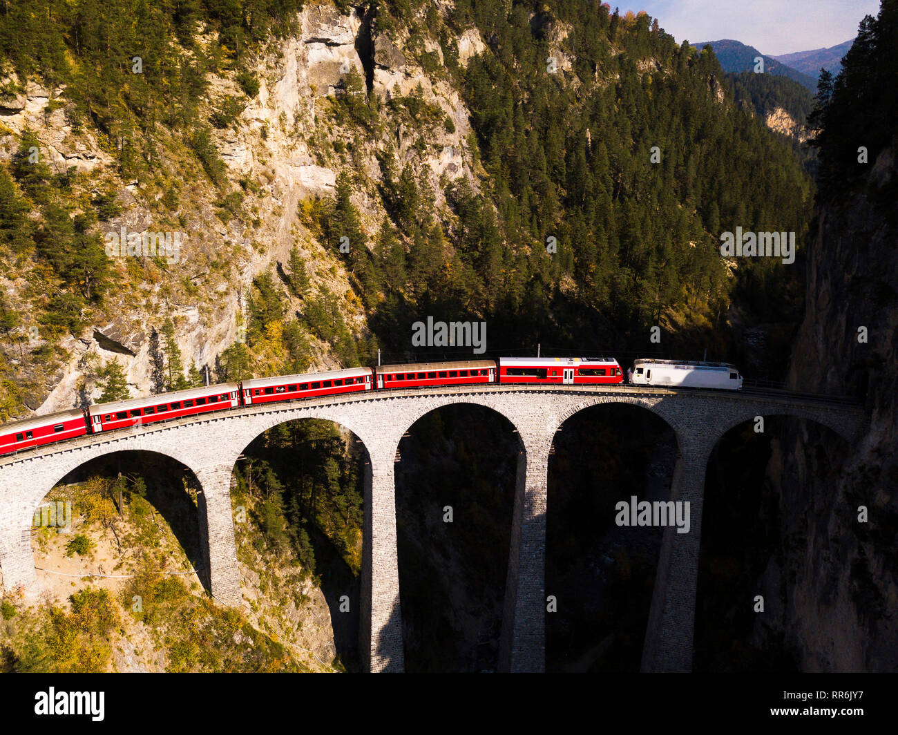 Aerial View of a red train crossing the Landwasser Viaduct in the Swiss ...