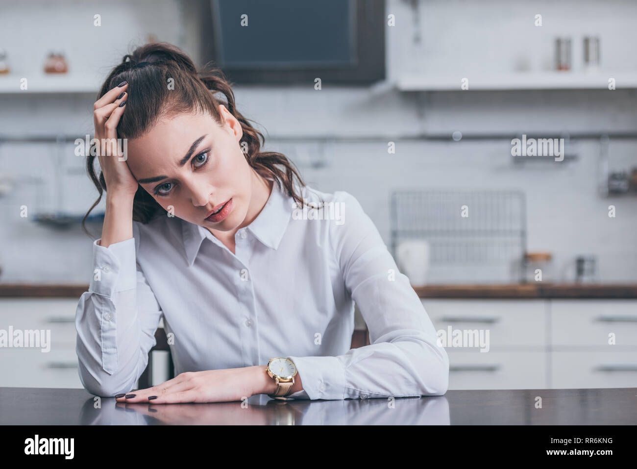 Sad woman kitchen table hi-res stock photography and images - Alamy