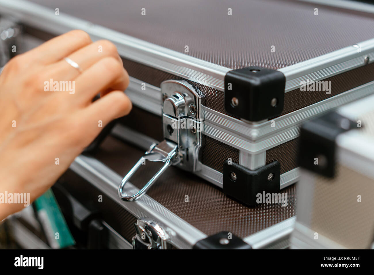 Female hand takes a small aluminum case Stock Photo - Alamy