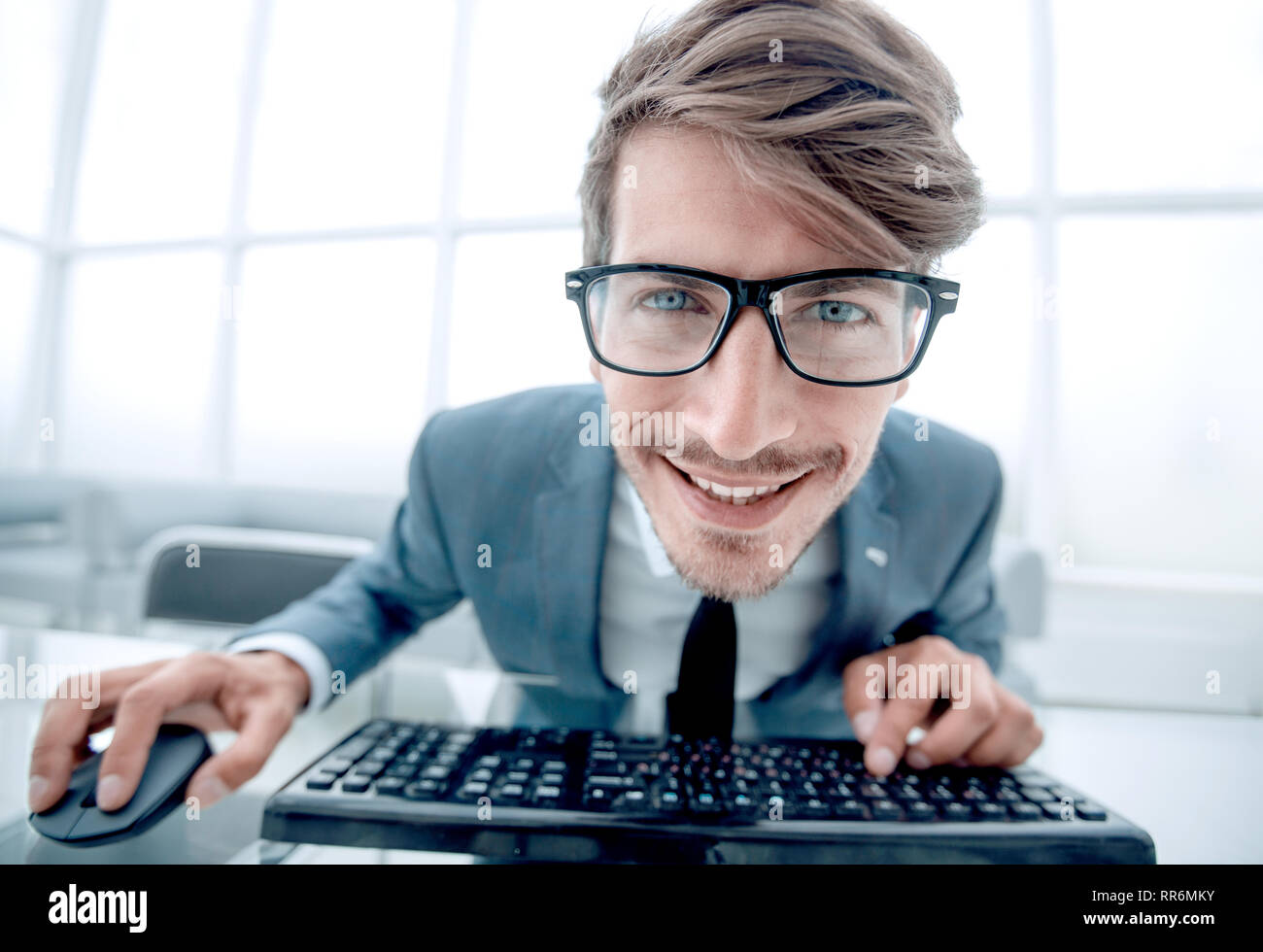 Crazy looking man typing on the keyboard Stock Photo - Alamy