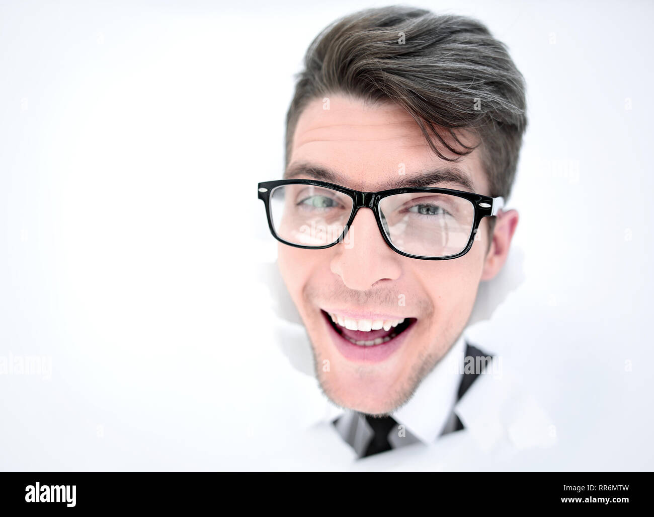 young businessman breaking through a paper wall Stock Photo - Alamy
