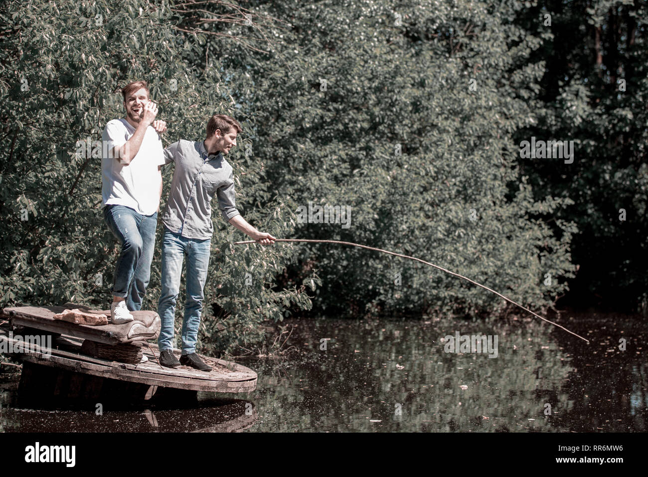 two friends are fishing on the lake in the early morning Stock Photo ...