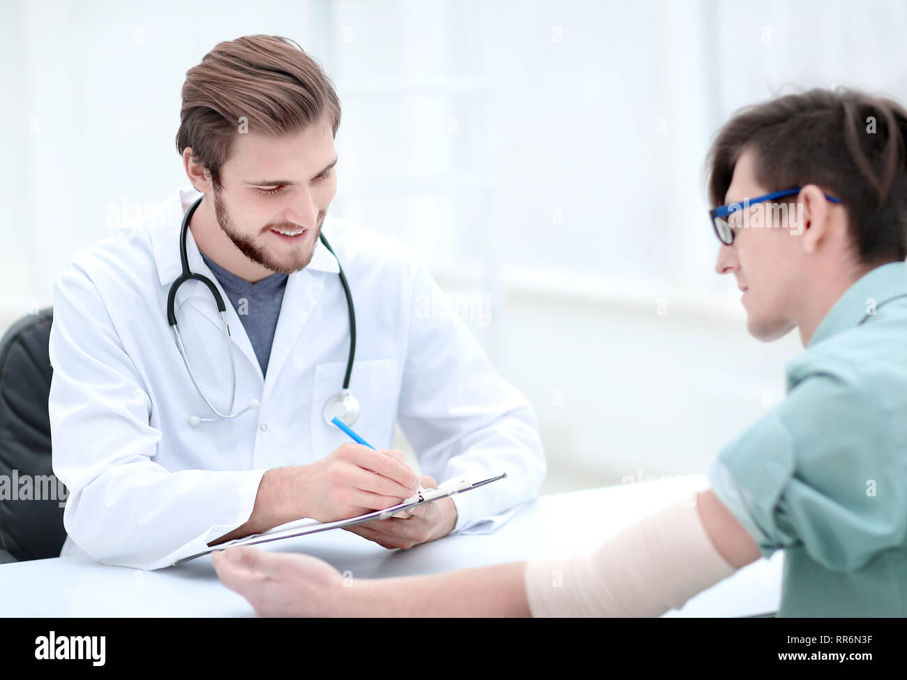 doctor writing a prescription to her patient Stock Photo - Alamy