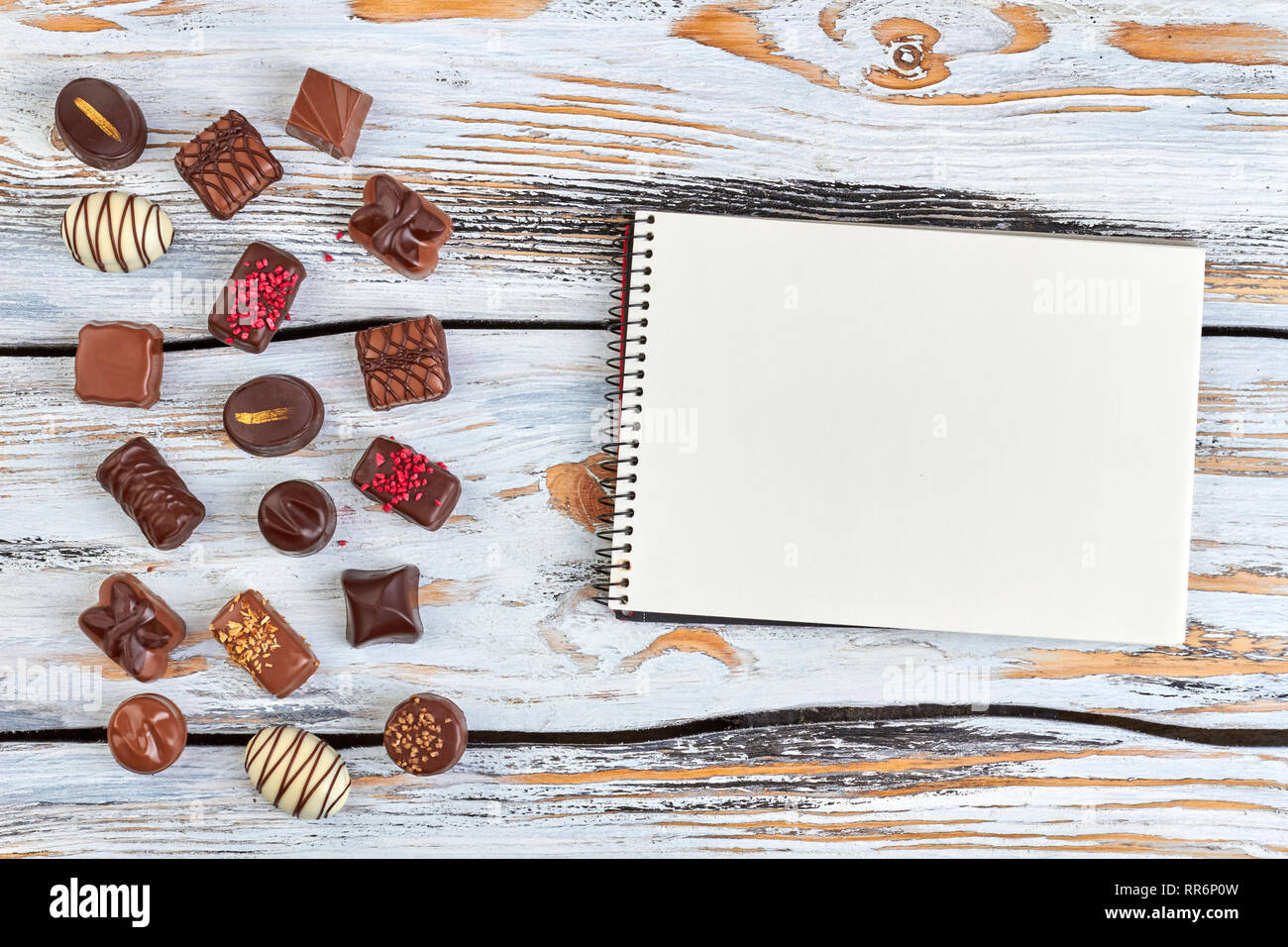Group of chocolate candies and paper notebook Stock Photo - Alamy