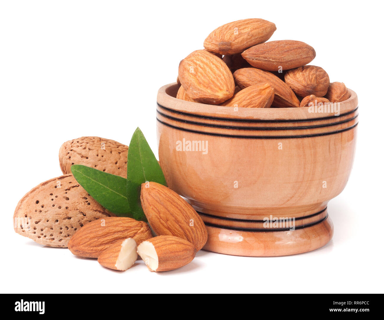 heap of almonds in their skins and peeled with leaf isolated on white ...