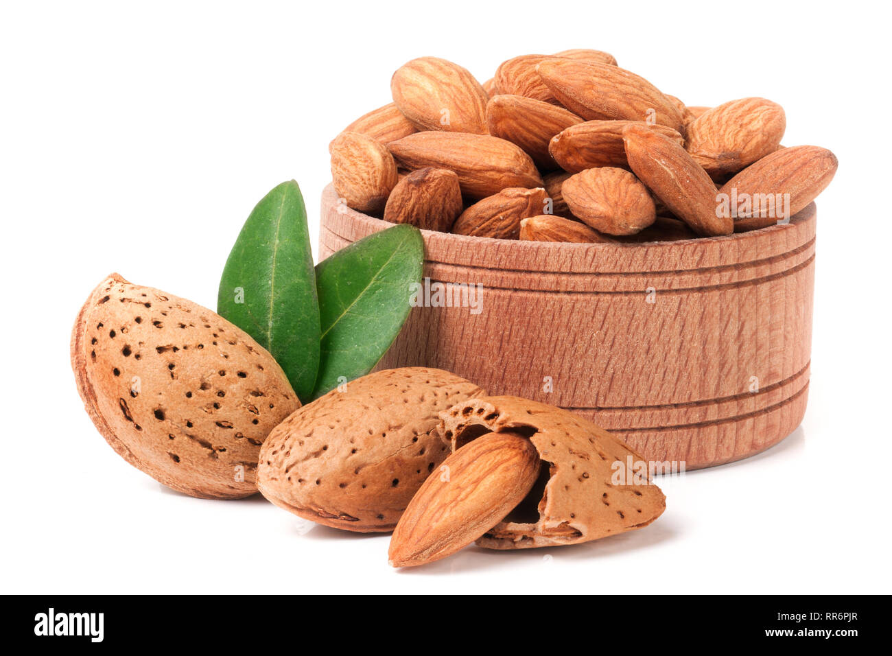 heap of almonds in their skins and peeled with leaf isolated on white ...