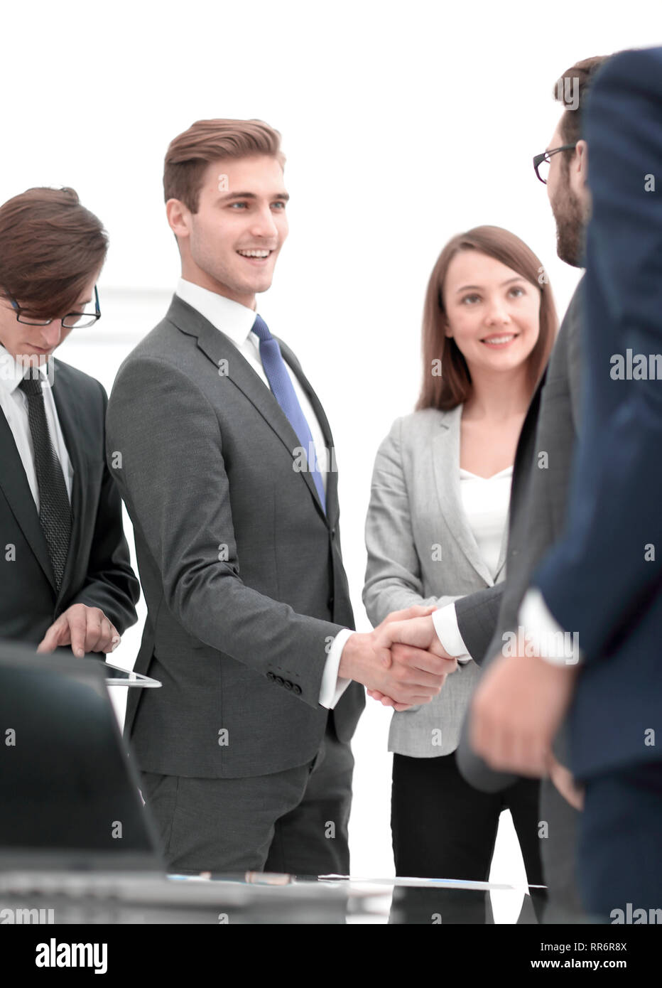 Business partners handshaking with their colleagues Stock Photo - Alamy