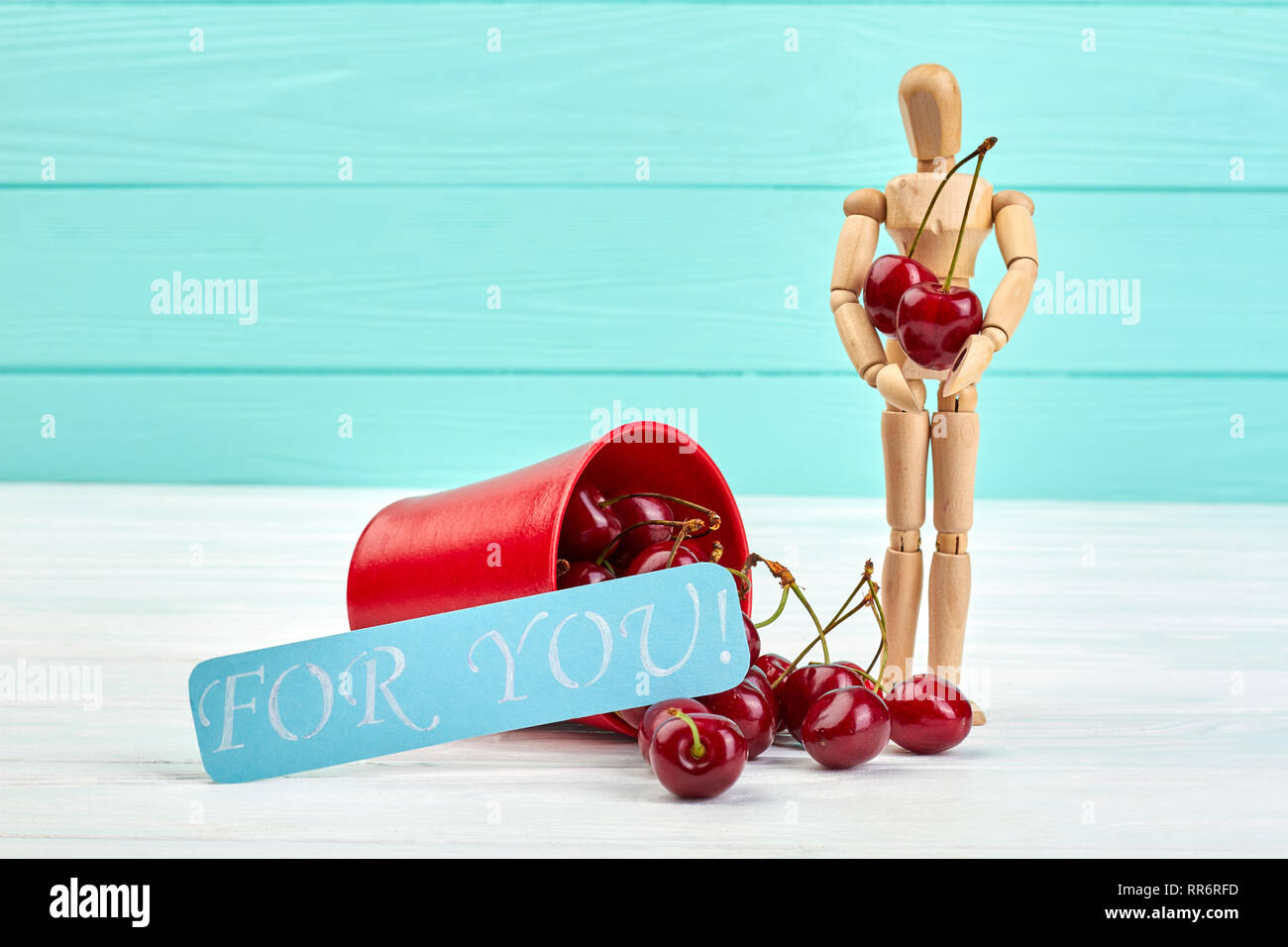 Wooden dummy with red ripe cherries Stock Photo - Alamy