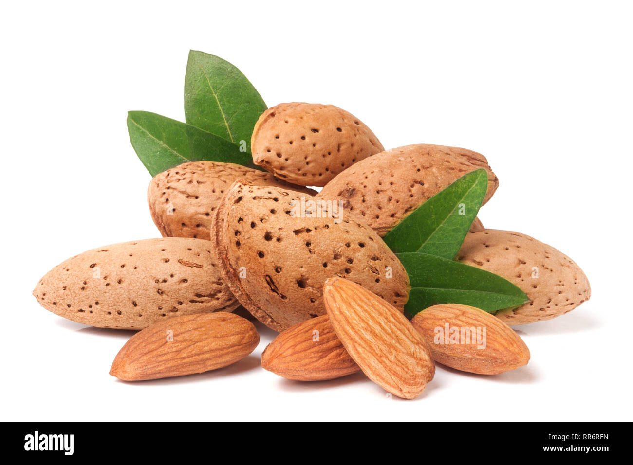 heap of almonds in their skins and peeled with leaf isolated on white ...