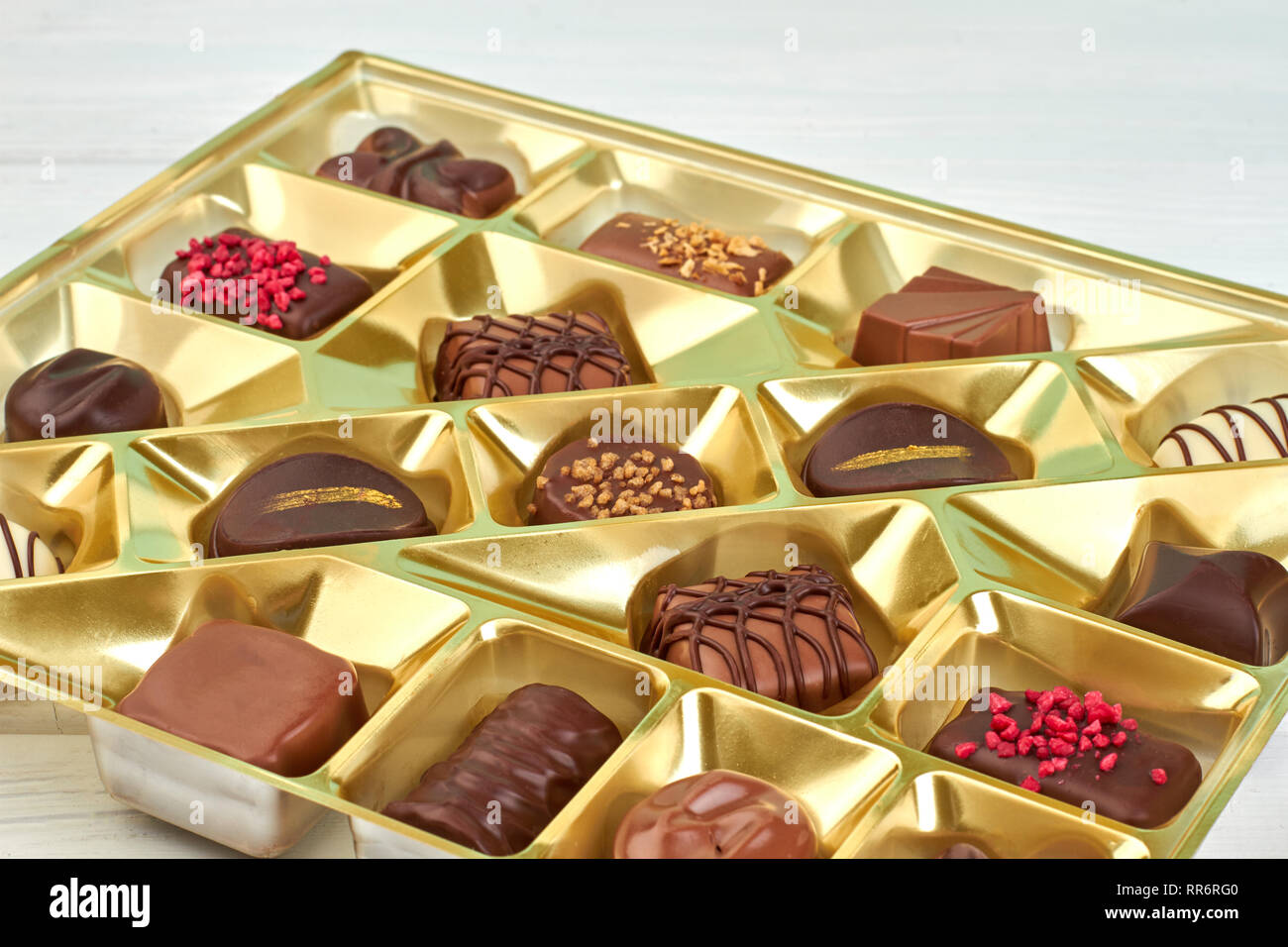 Collection of chocolate candies in golden box Stock Photo - Alamy