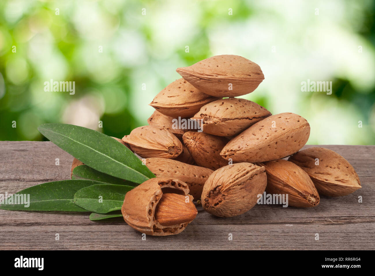 heap of almonds in their skins and peeled with leaf isolated on white ...