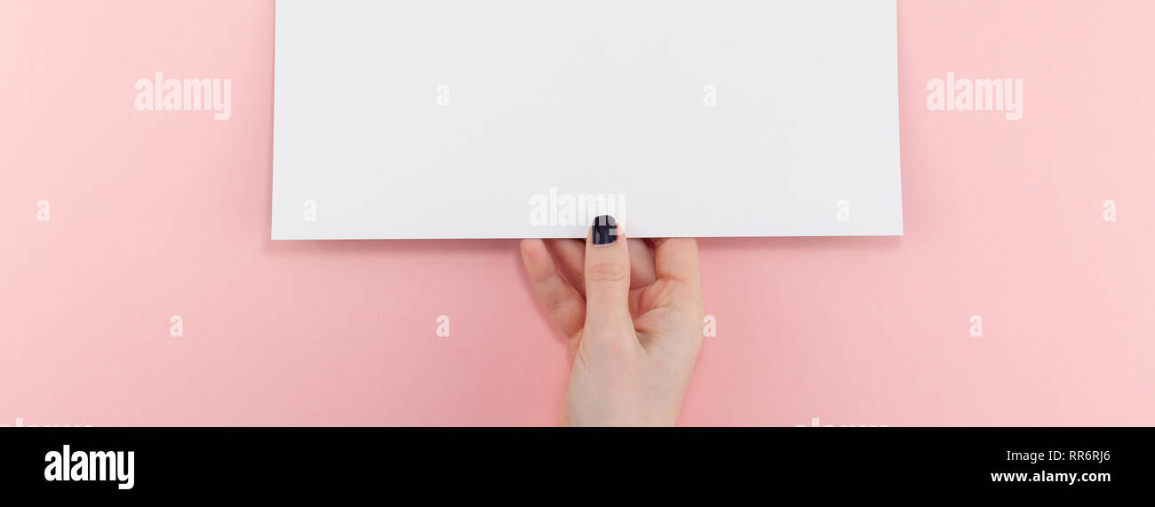 Creative flat lay top view of woman hands black manicure with empty A4 ...