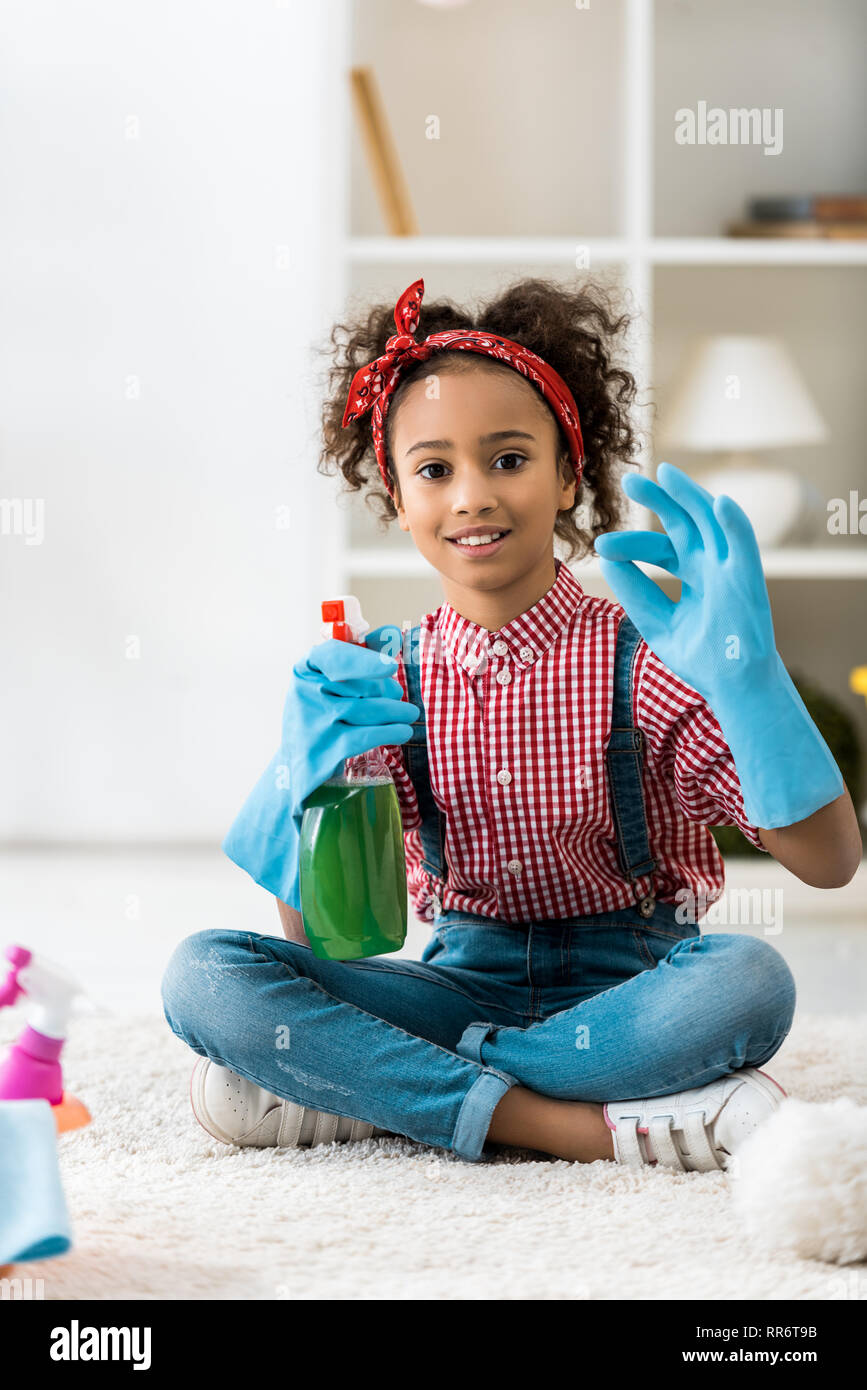 cute african american child in blue rubber gloves showing ok sign while sitting in lotus pose Stock Photo Alamy