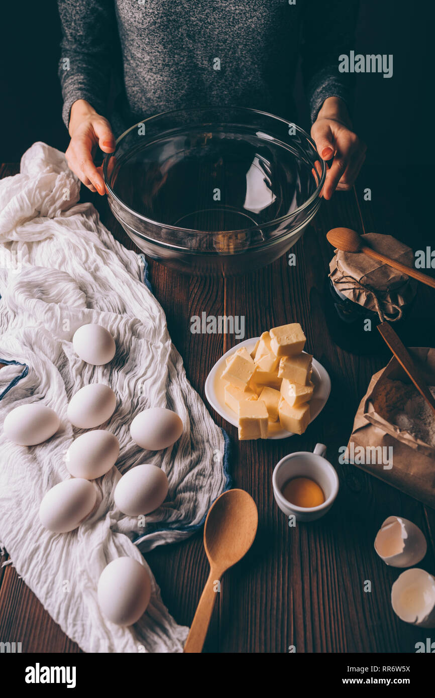 Young woman cooking pie. Cropped image of woman sitting at table ...