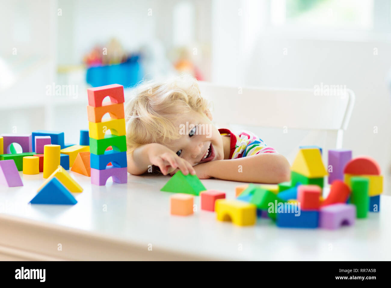 Kid playing with colorful toy blocks. Little boy building tower of ...