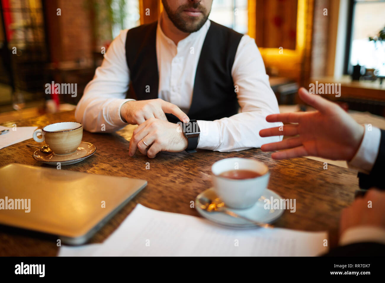 Man pointing at watch sitting hi-res stock photography and images - Alamy