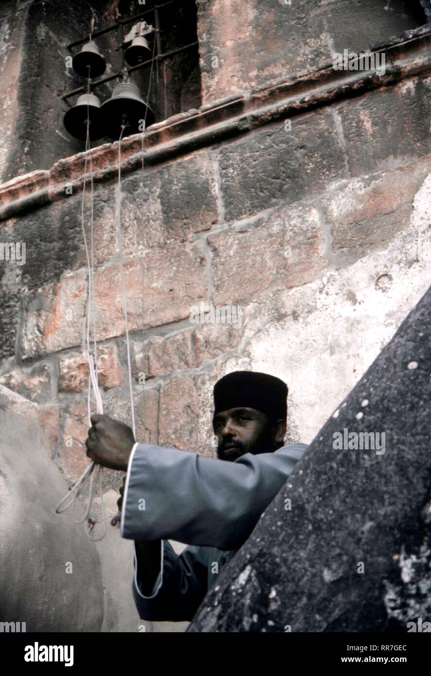 Ethiopian monk ringing bells for service at the Church of the Holy ...