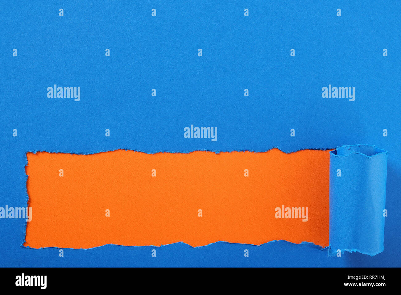 Torn blue paper strip orange background Stock Photo - Alamy
