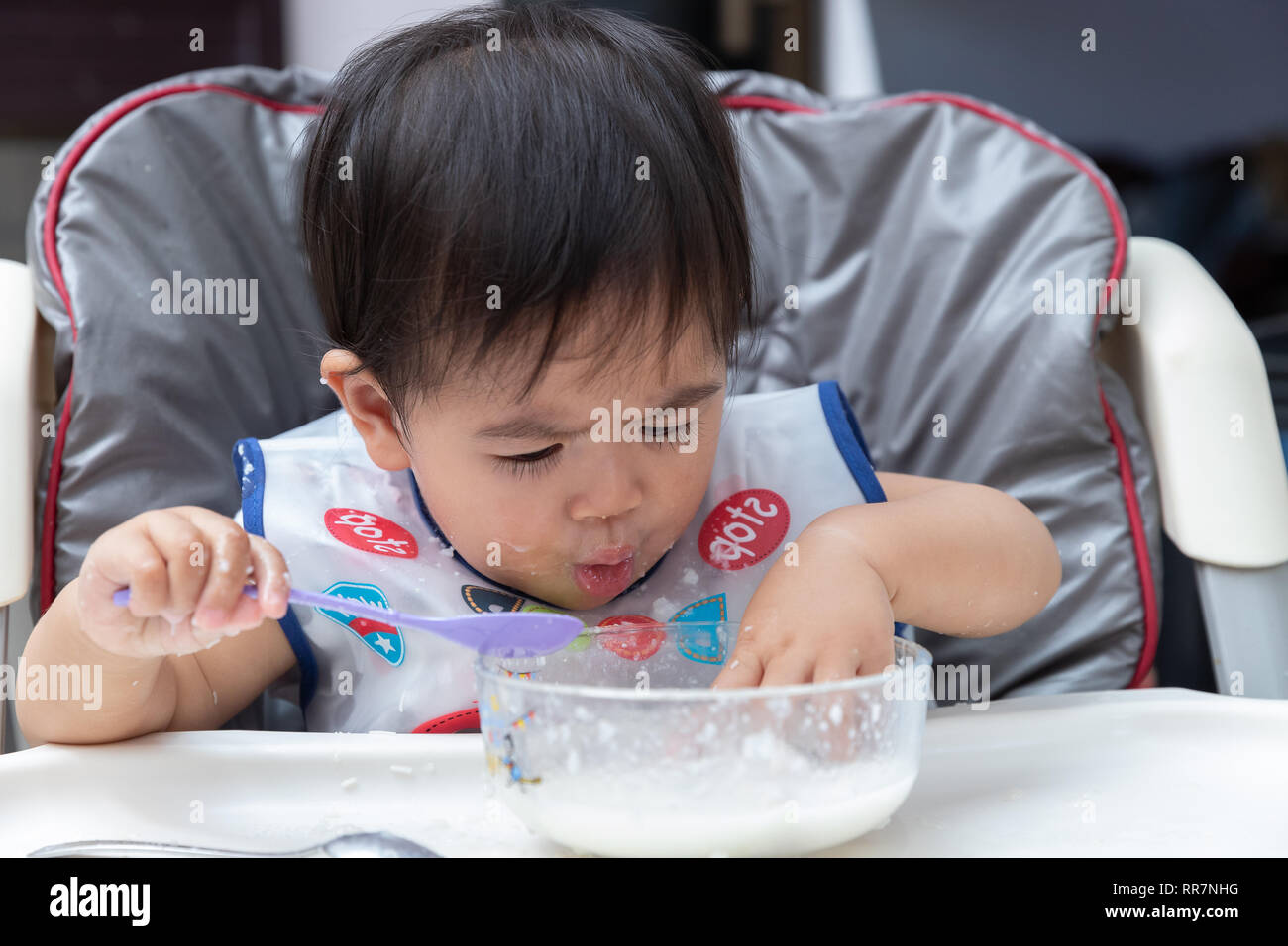 Close up baby eating meal by herself Stock Photo - Alamy