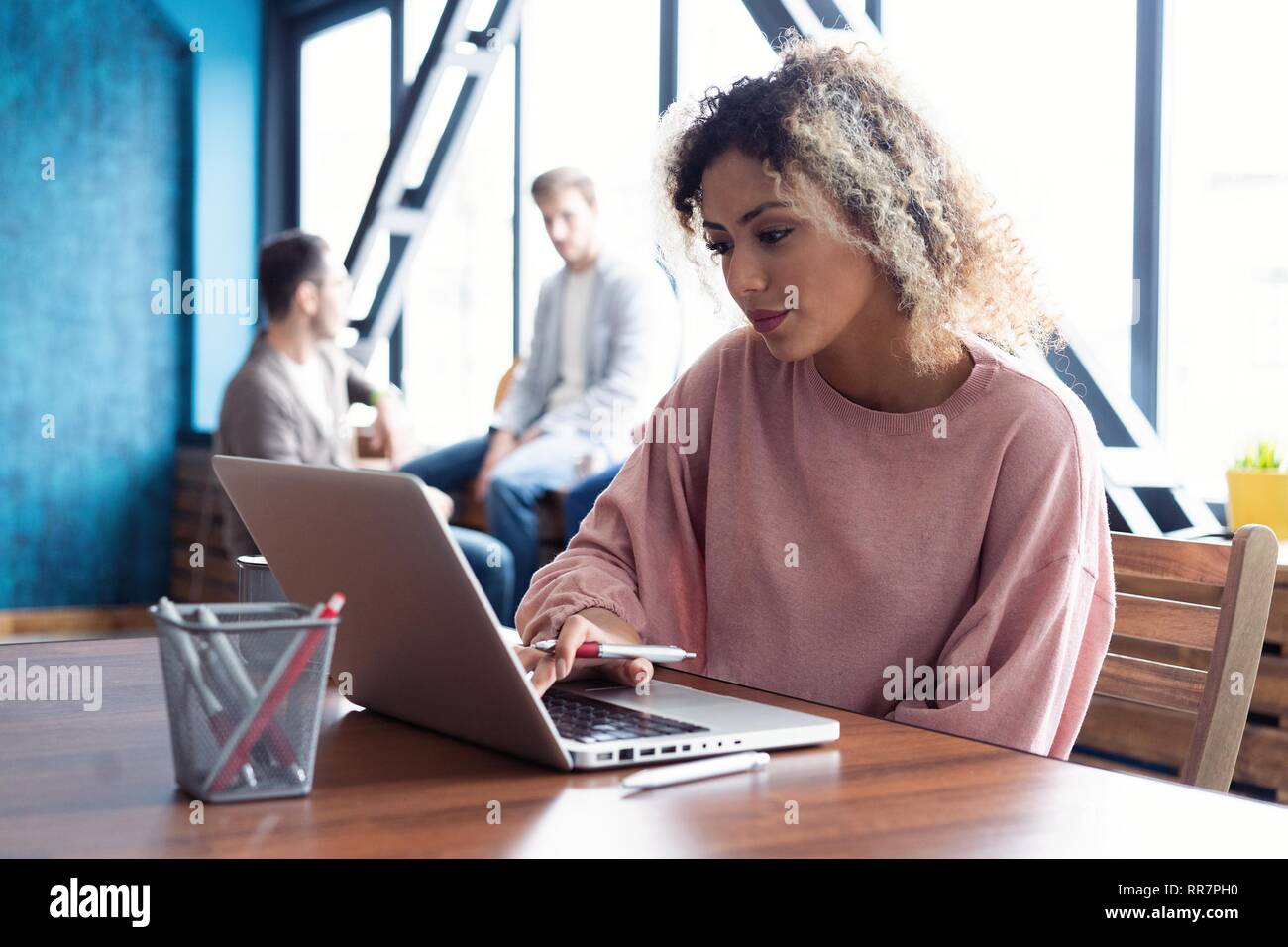 Beautiful business African lady is looking at camera and smiling while ...