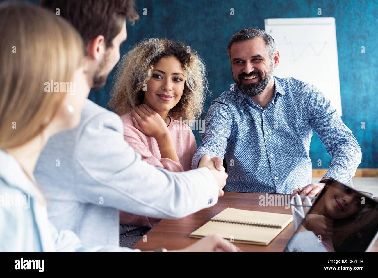 Welcome To Our Team Young Modern Men In Smart Casual Wear Shaking Hands While Working In The