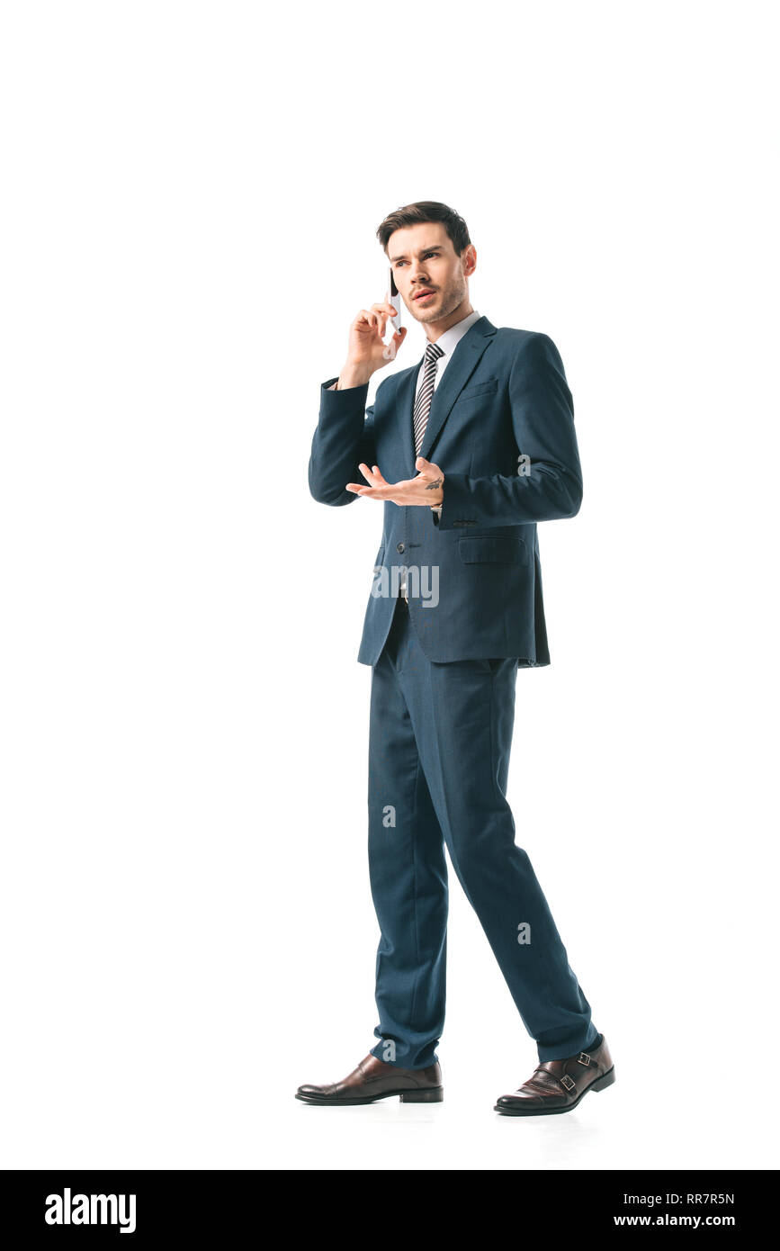 confused businessman in suit talking on smartphone isolated on white ...