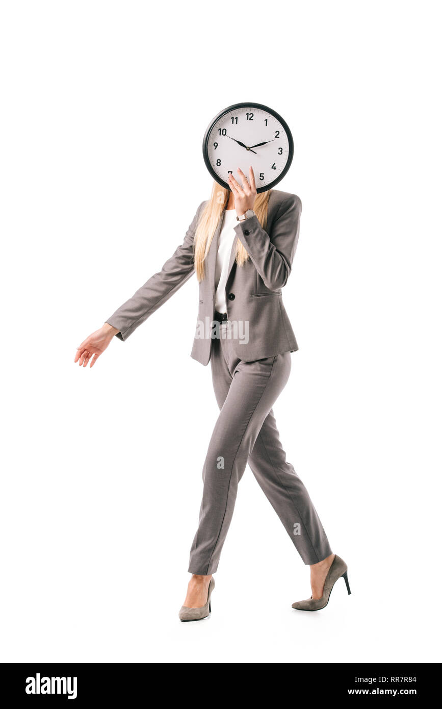 businesswoman in grey suit holding clock in front of the face while ...