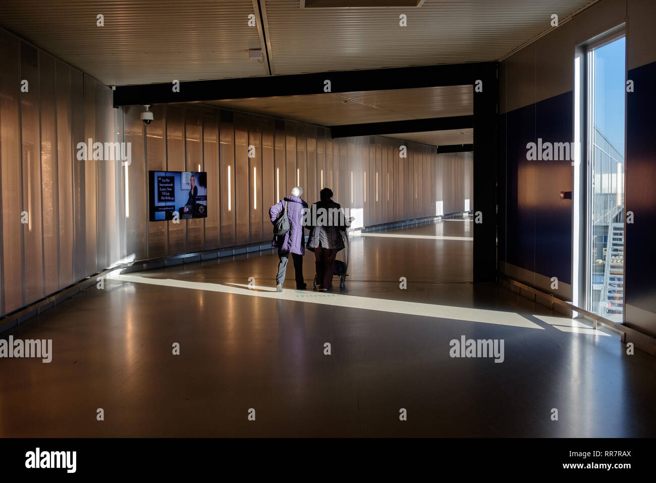 Passengers pulling luggage from Copenhagen airport terminal building ...