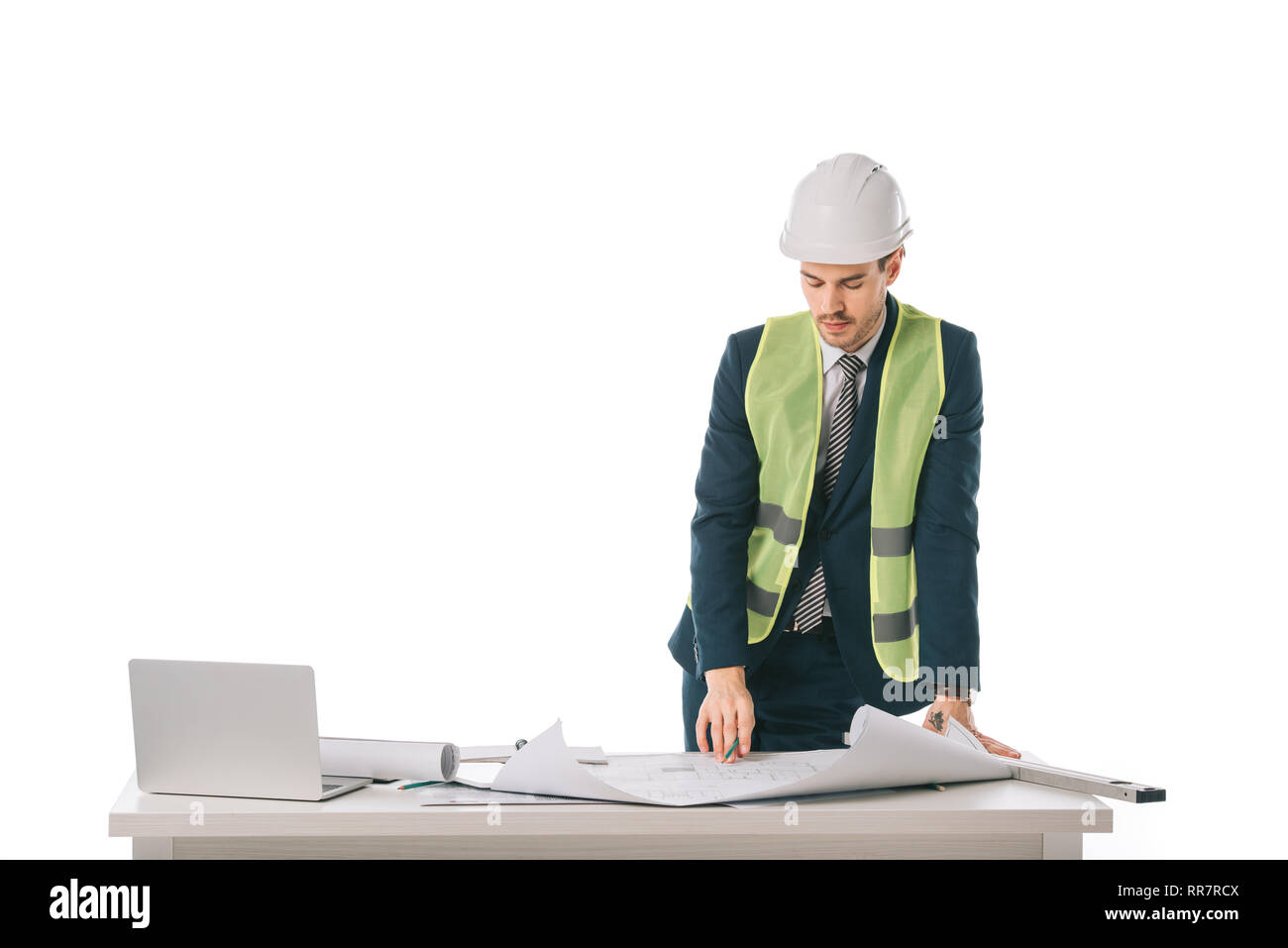 male architect in helmet and safety vest working with blueprints and ...
