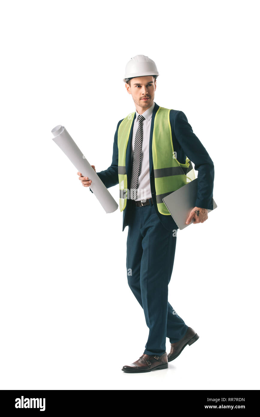 male architect in hardhat and safety vest walking with blueprint and ...