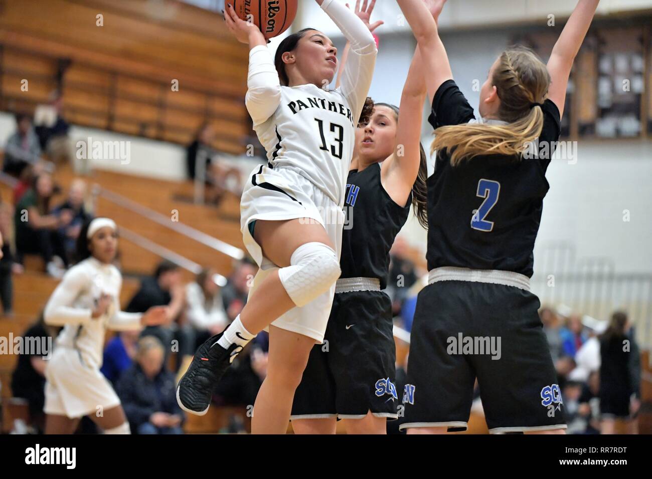 Player trying to execute a driving layup around and over a pair of ...