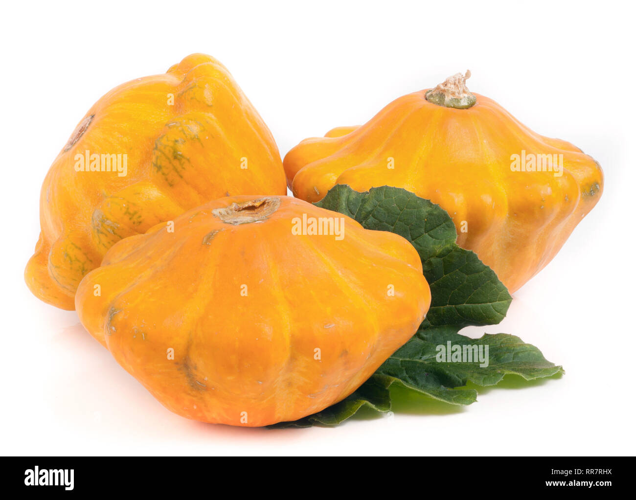 three yellow pattypan squash with leaf isolated on white background ...