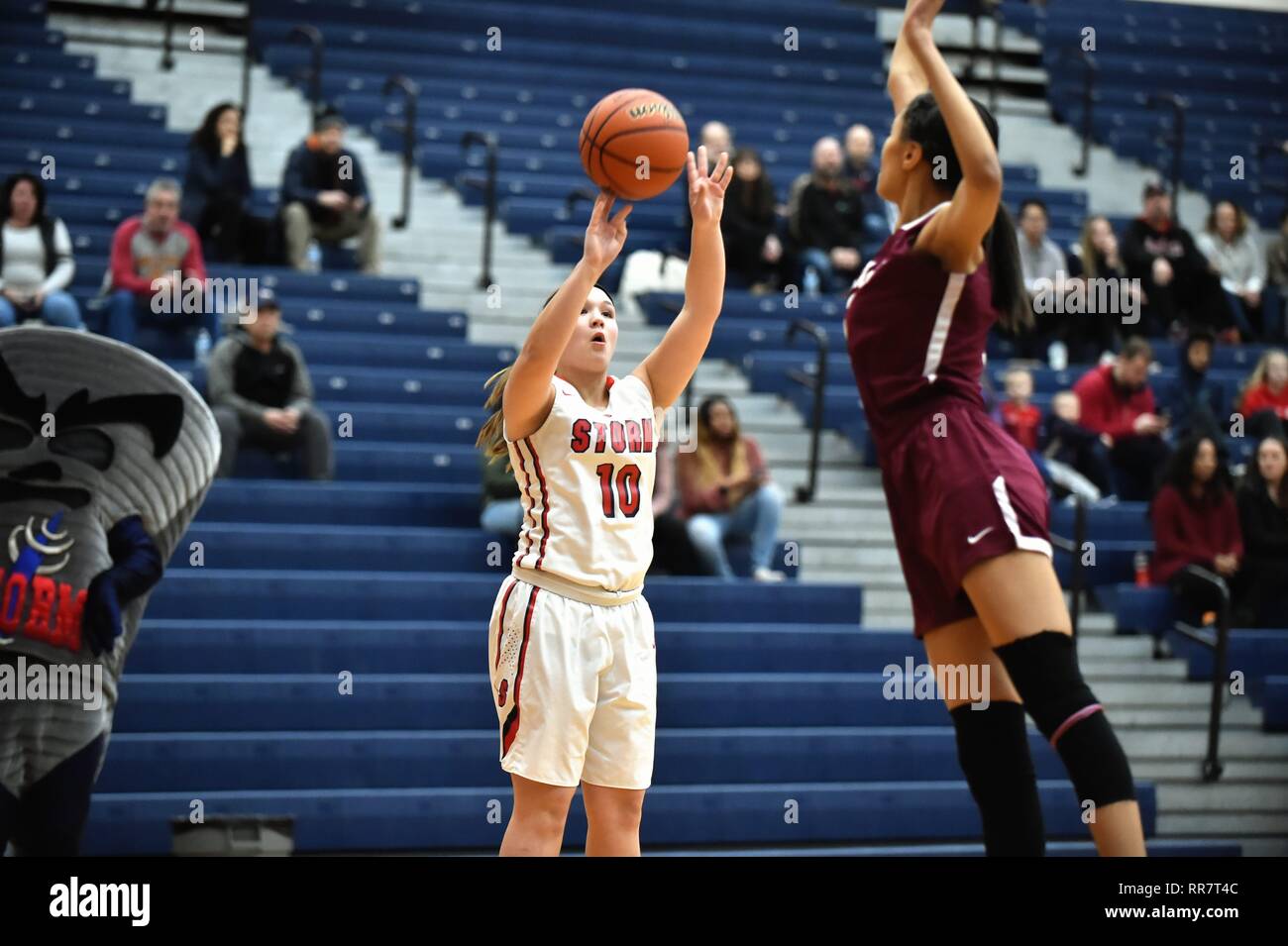 Player releasing a three-point shot from behind the arc while pressured ...