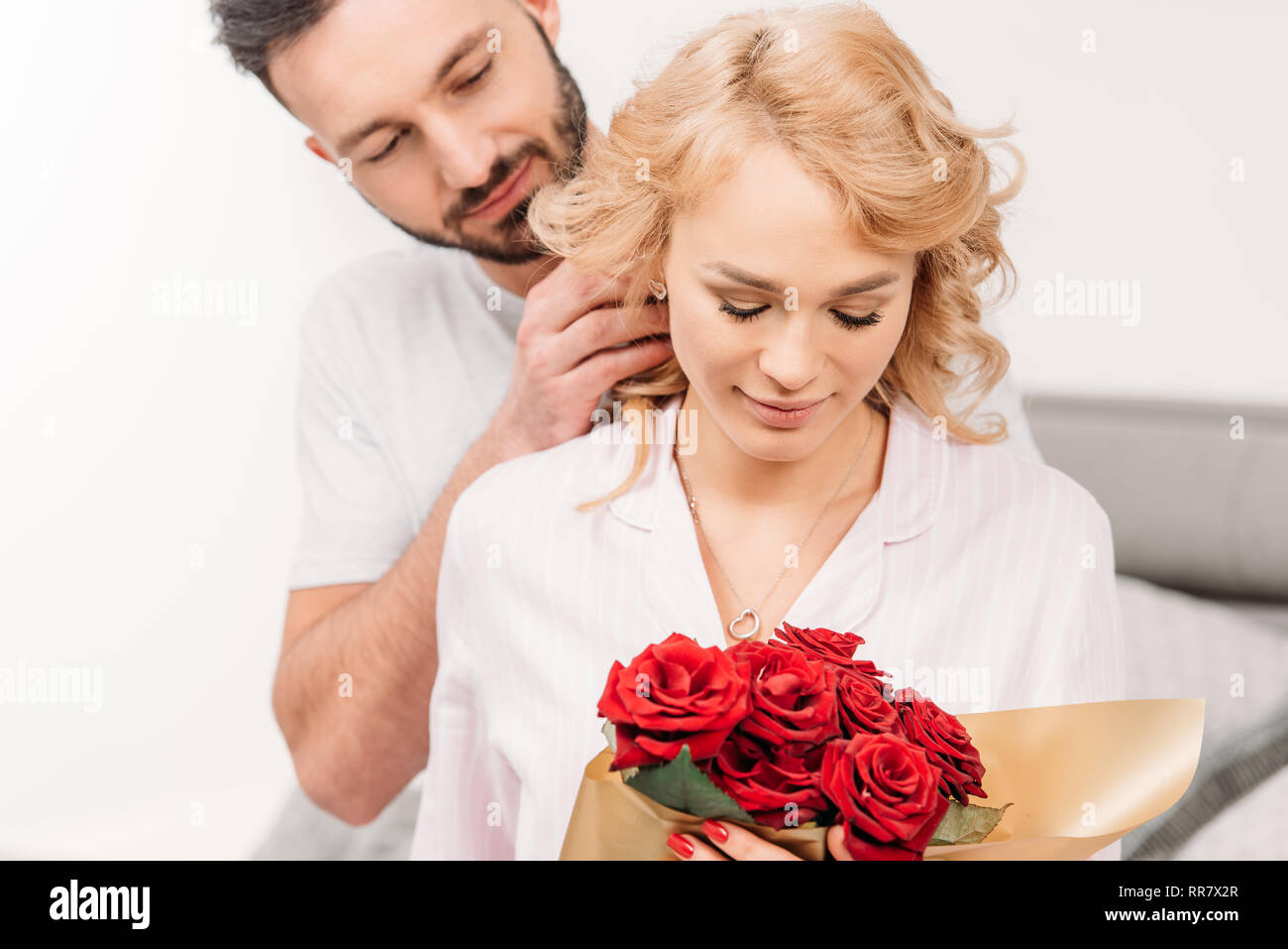 Relaxed romantic couple posing with red roses Stock Photo - Alamy