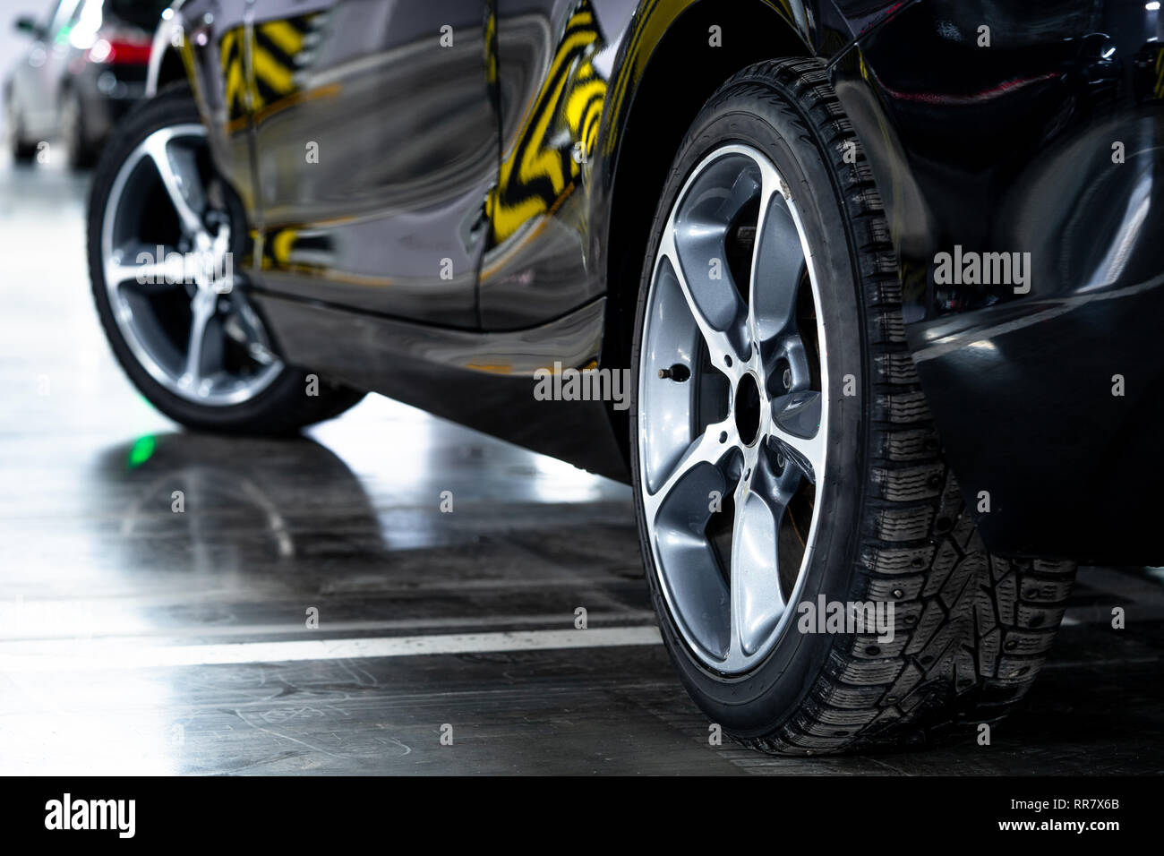 Modern car exterior. Driver's door, wheels. Luxury black car on parking ...