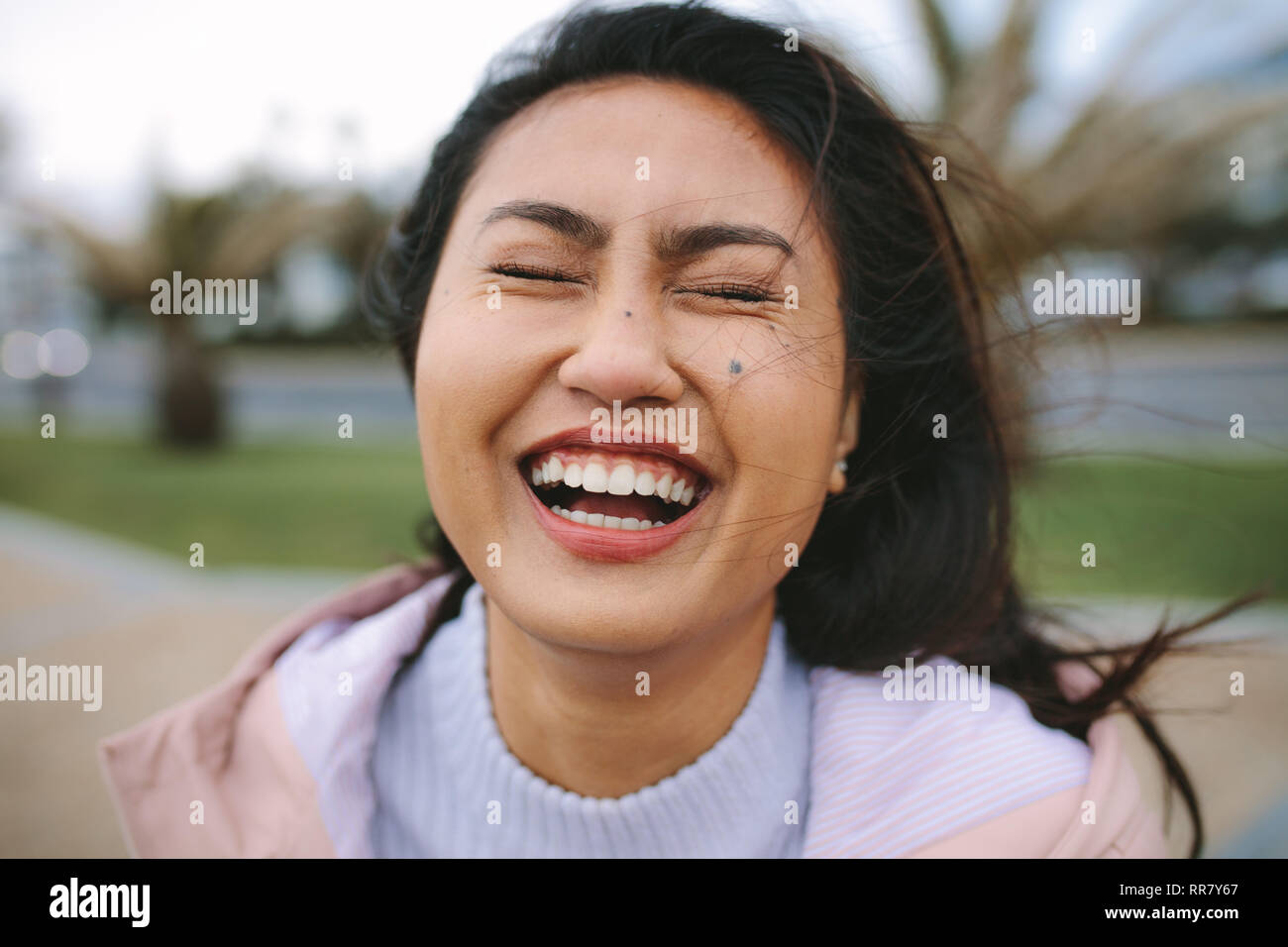 Portrait of a woman standing outdoors and laughing. Close up of an ...
