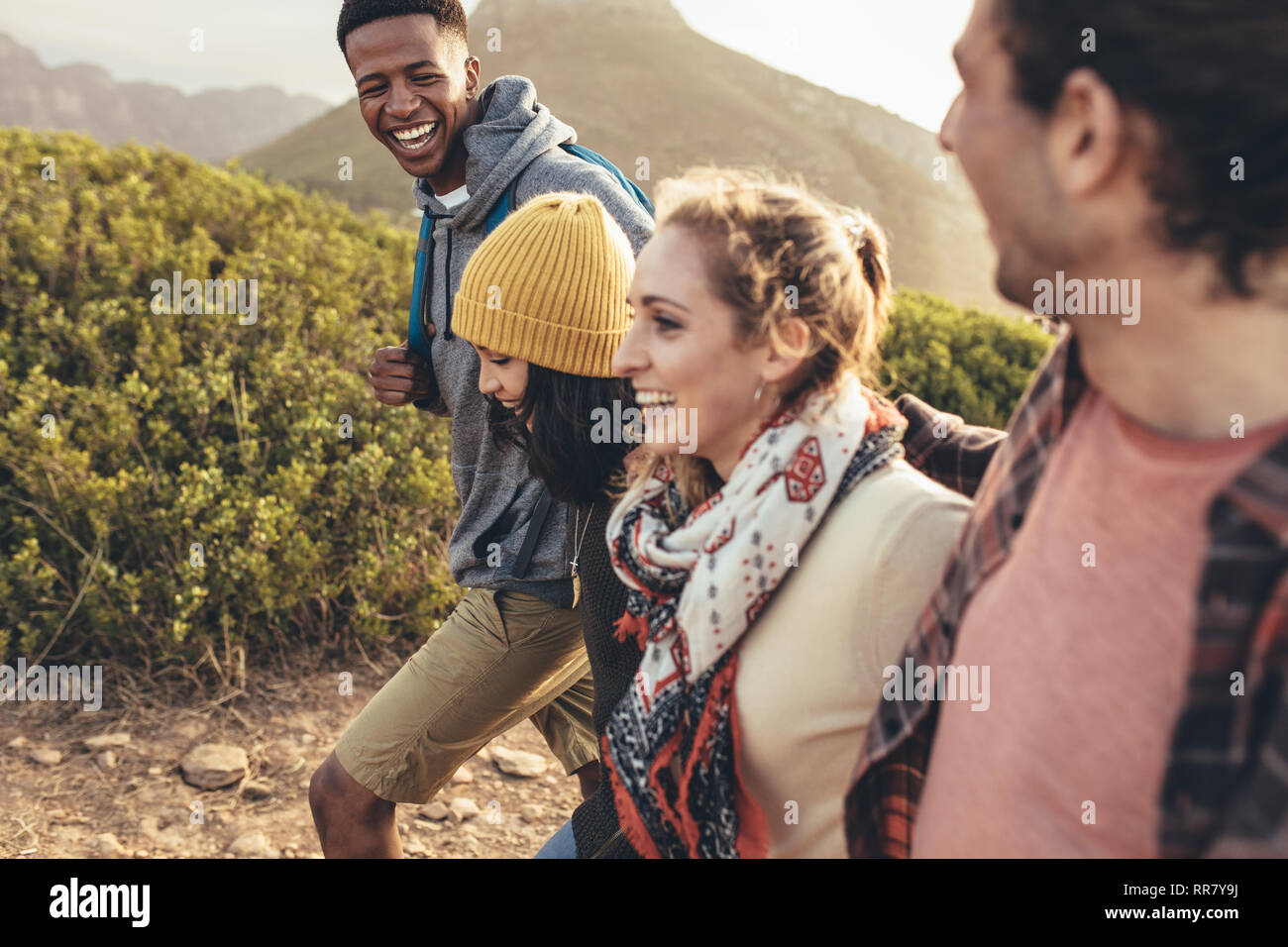 Cheerful young man laughing while hiking with friends. Friends having ...