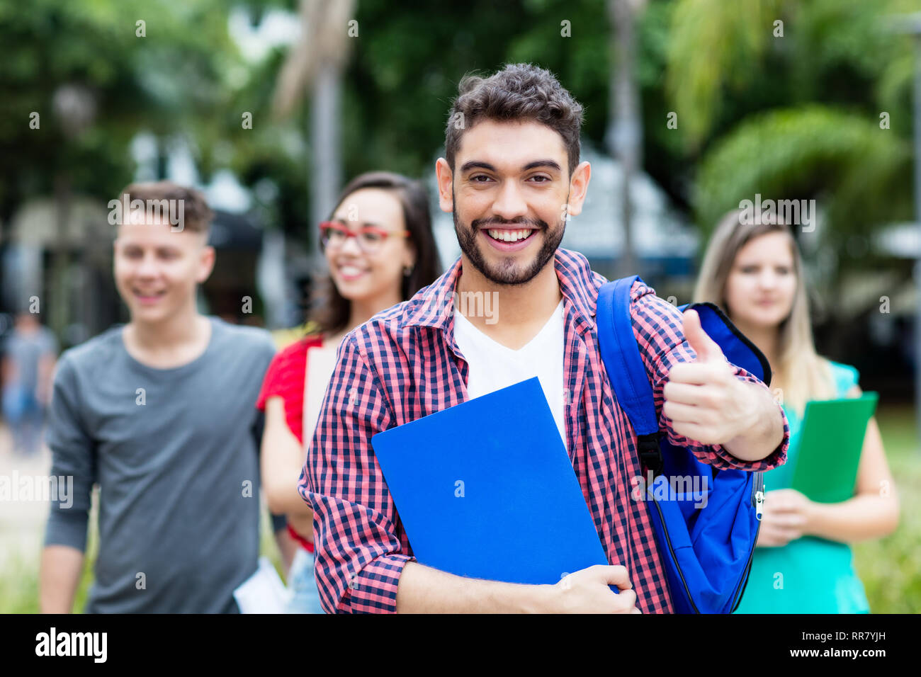 Spanish male student with group of other students outdoor in the summer ...