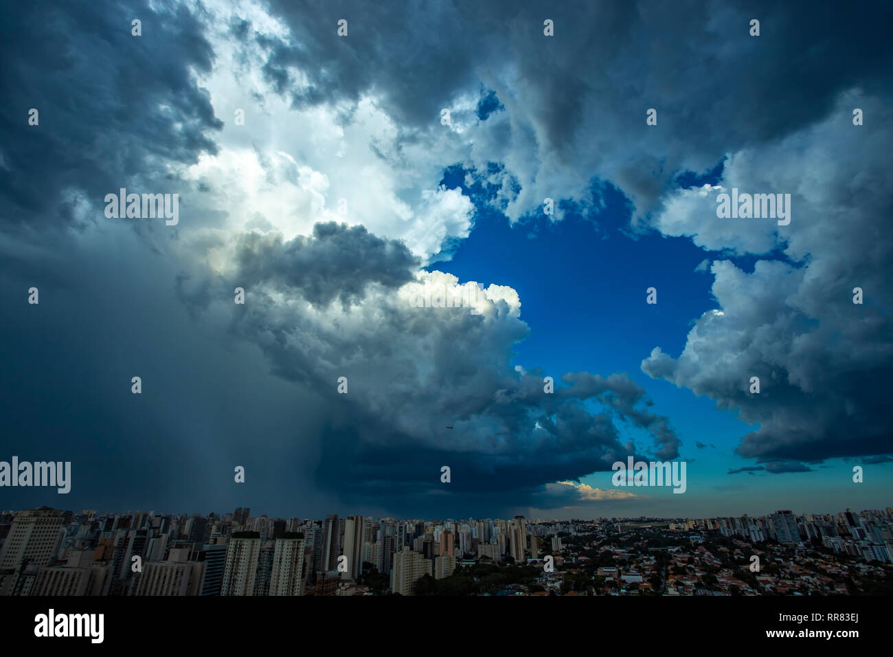 Dark and dramatic clouds of rain. Airplane taking off with storm clouds ...