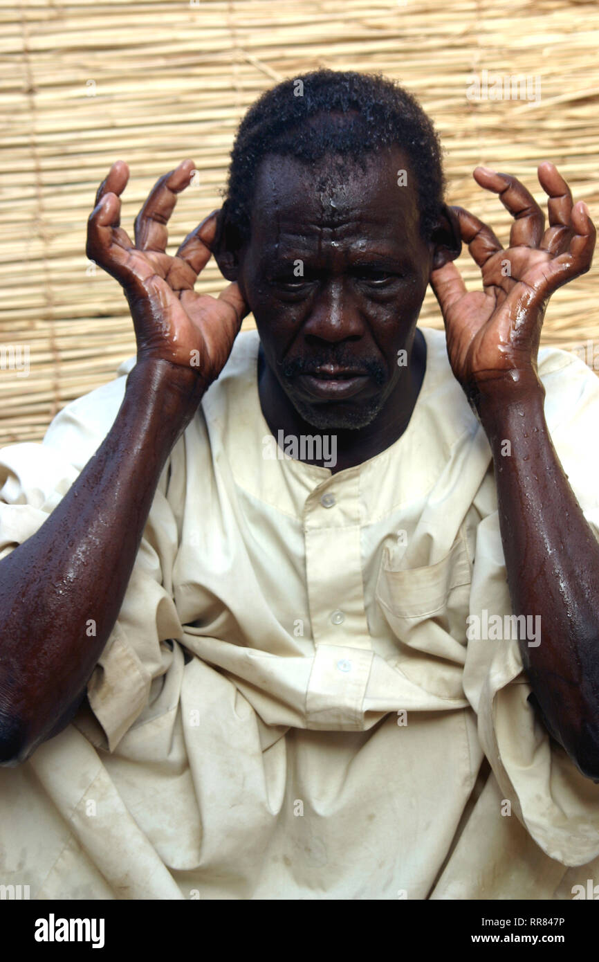 A Muslim man in Chad performs ablutions, known as wudu, before offering ...